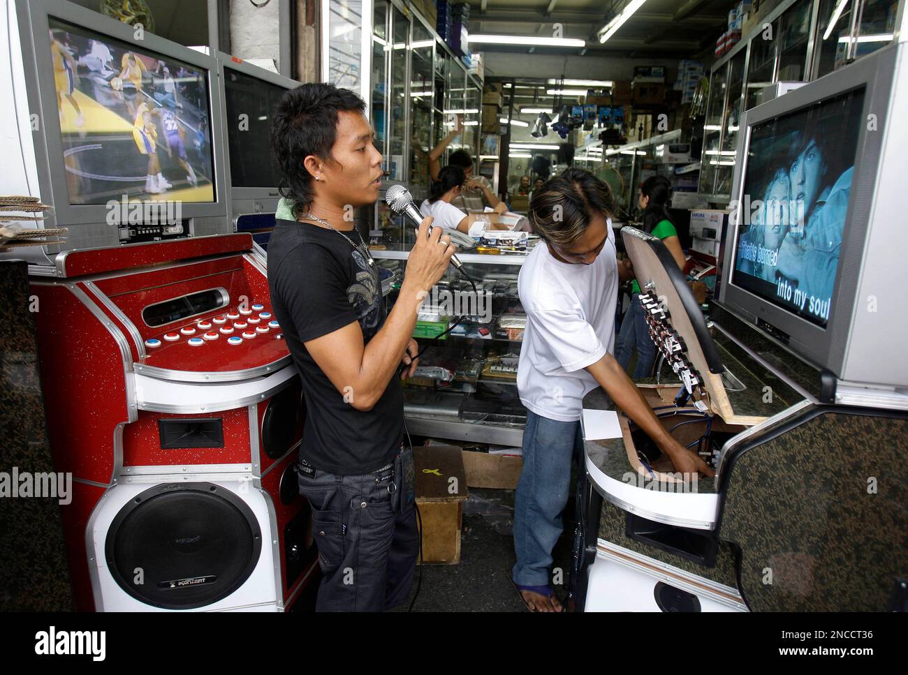 A Filipino worker tests a newly-built karaoke machine which sells for ...