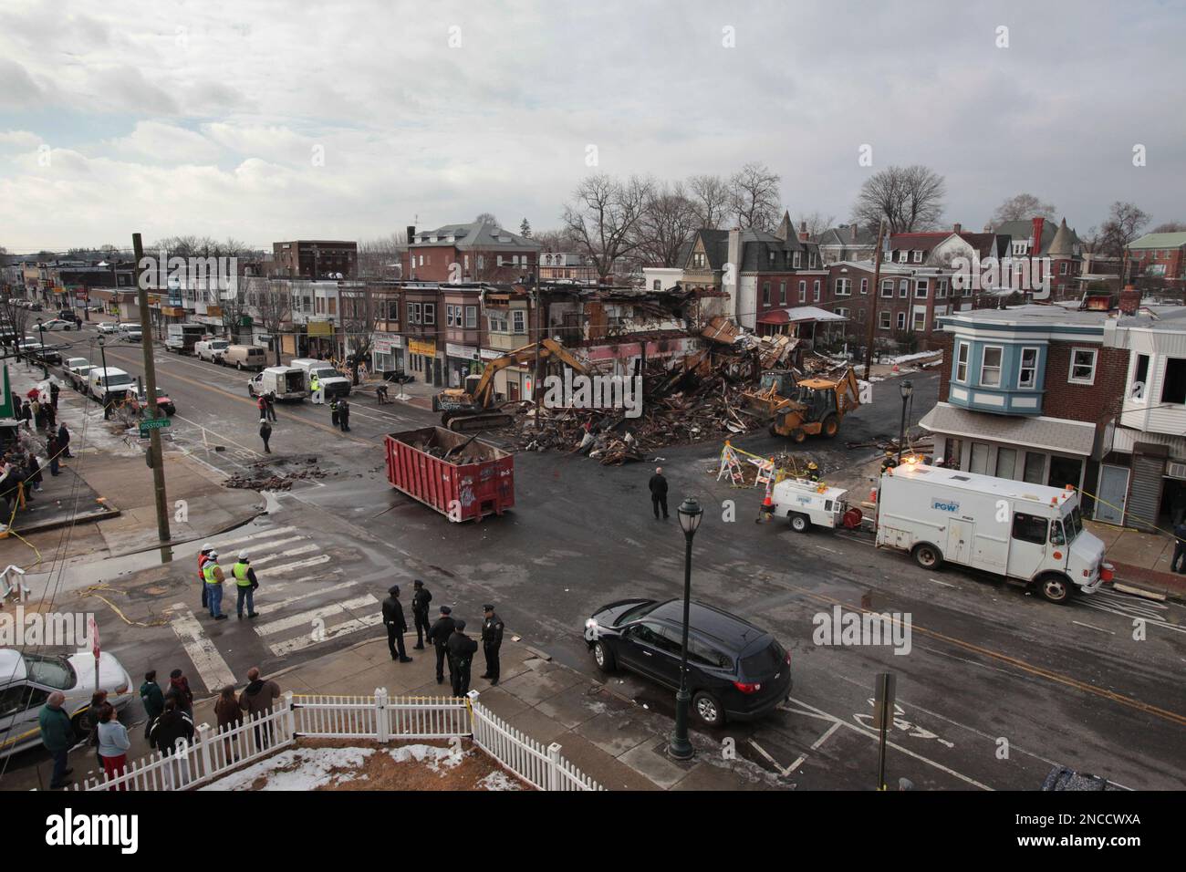 Crews remove debris from the site of a gas main explosion in ...
