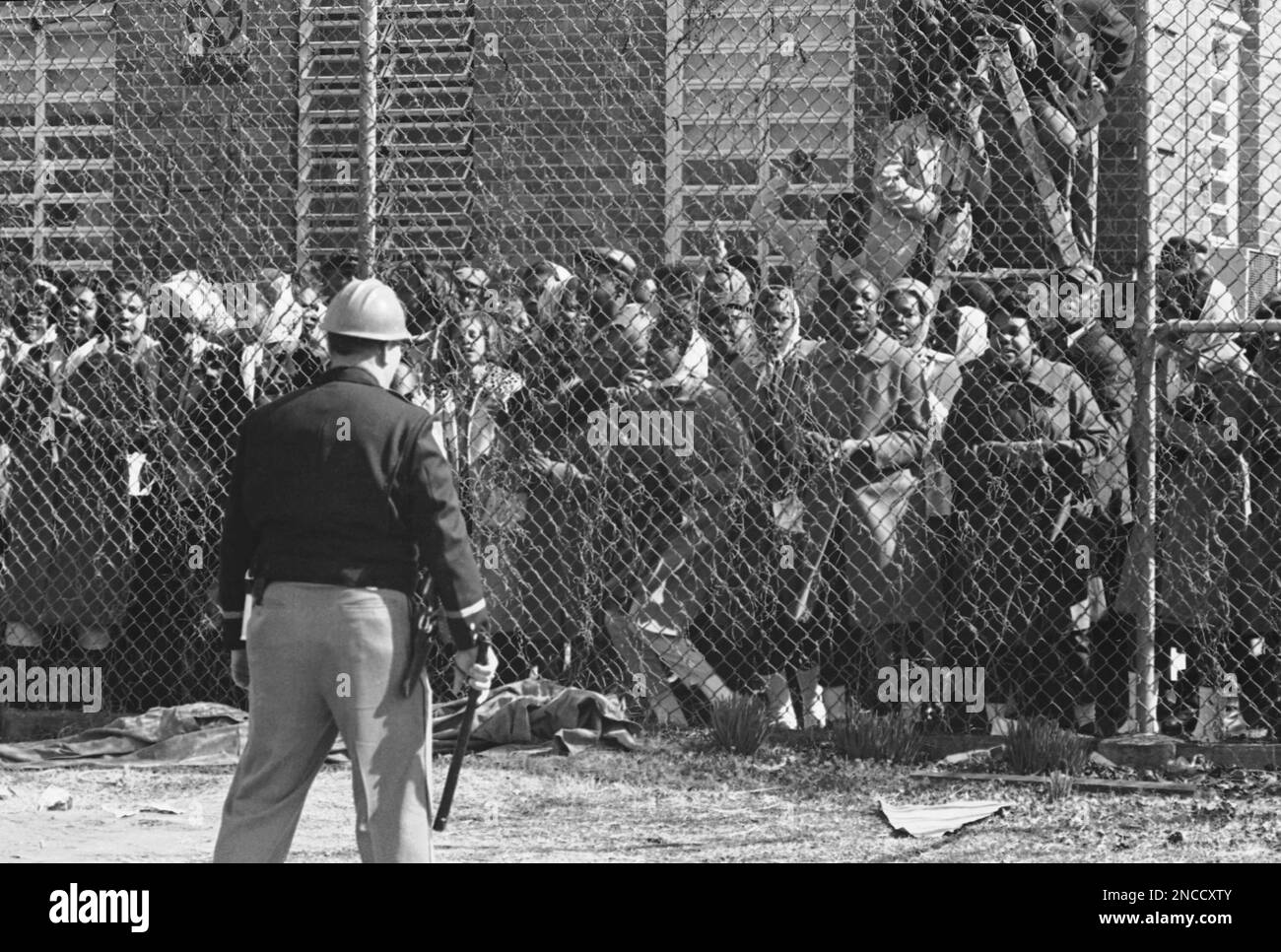 A policeman stands guard outside a fence surrounding the Perry County ...