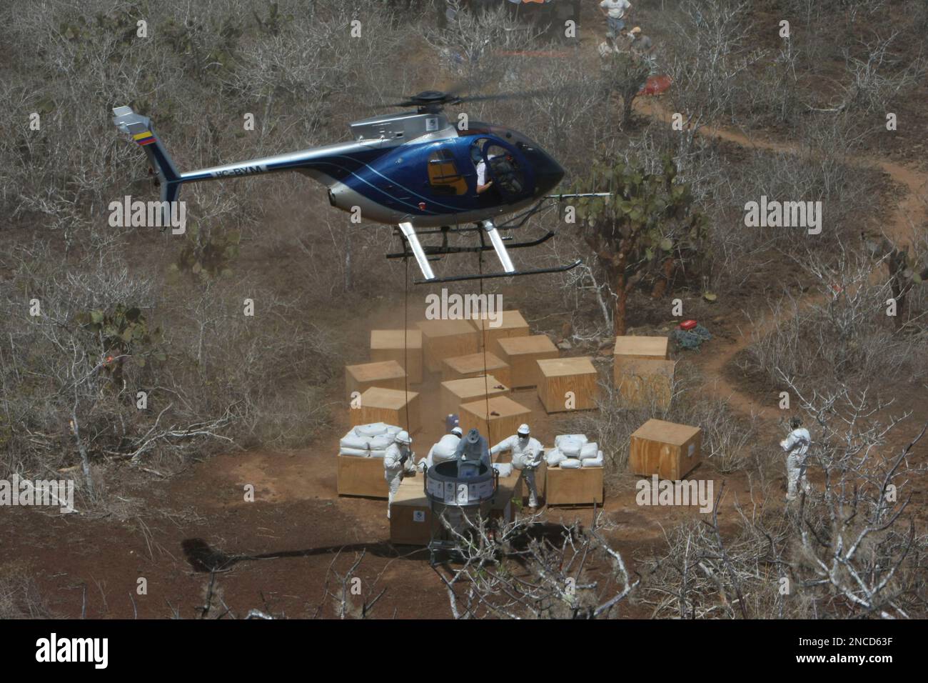 A helicopter is loaded with rat bait in Rabida Island, Galapagos ...