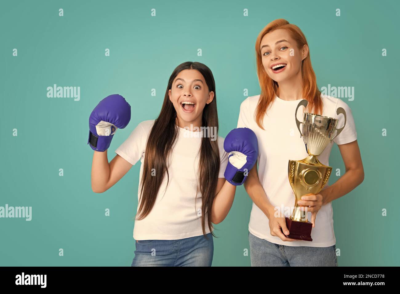 Mommy and teen daughter in boxing gloves holding winning prize, showing ...
