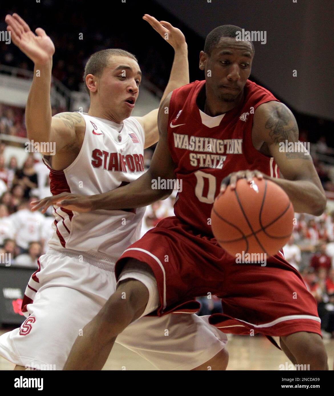 Washington State's Marcus Capers, right, looks for a way around ...