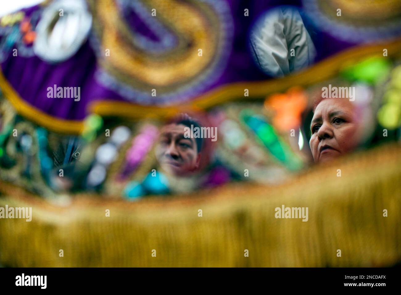 Pilgrims are reflected in small mirrors covering the costume of a ...