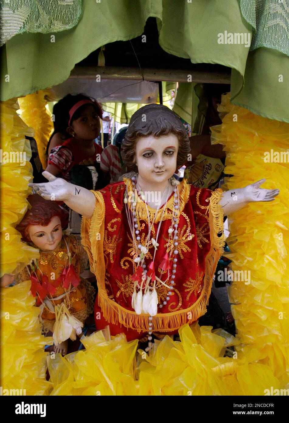 An image of the Infant Jesus is place in front of a bicycle rickshaw ...