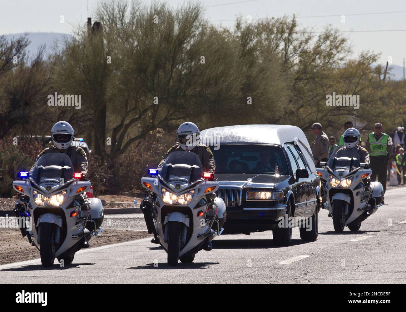 A hearse with the remains of U.S. District Judge John Roll leaves St ...