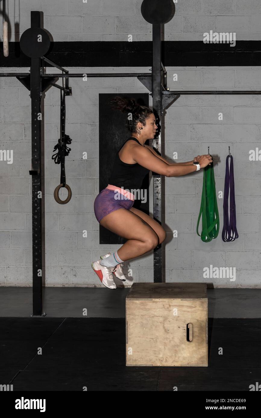 woman jumping on a box as part of exercise routine. Fitness woman doing ...