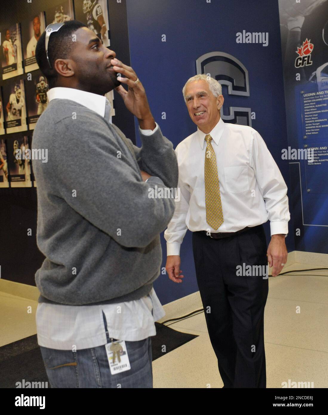 New Connecticut head football coach Paul Pasqualoni, right, talks with ...