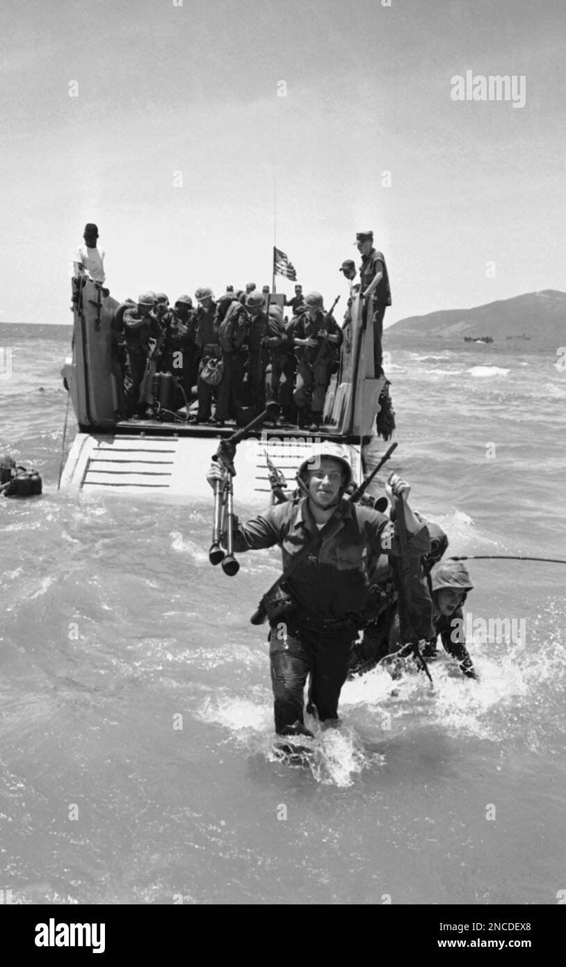A U.S. Marine falls in surf as he follows buddy ashore from landing ...
