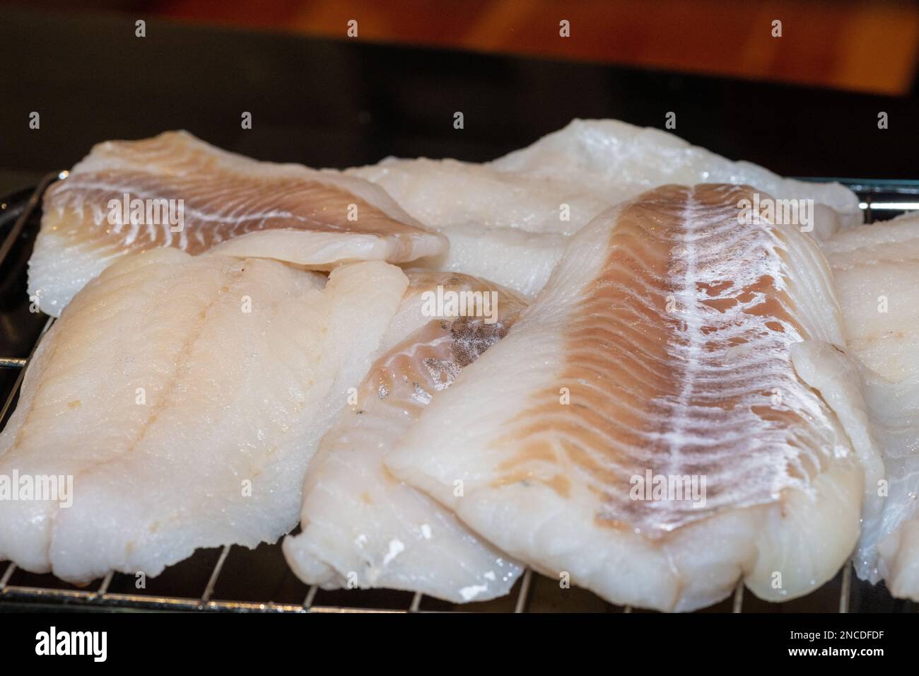 Close up with multiple pieces of raw thick, healthy white fish uncooked ...