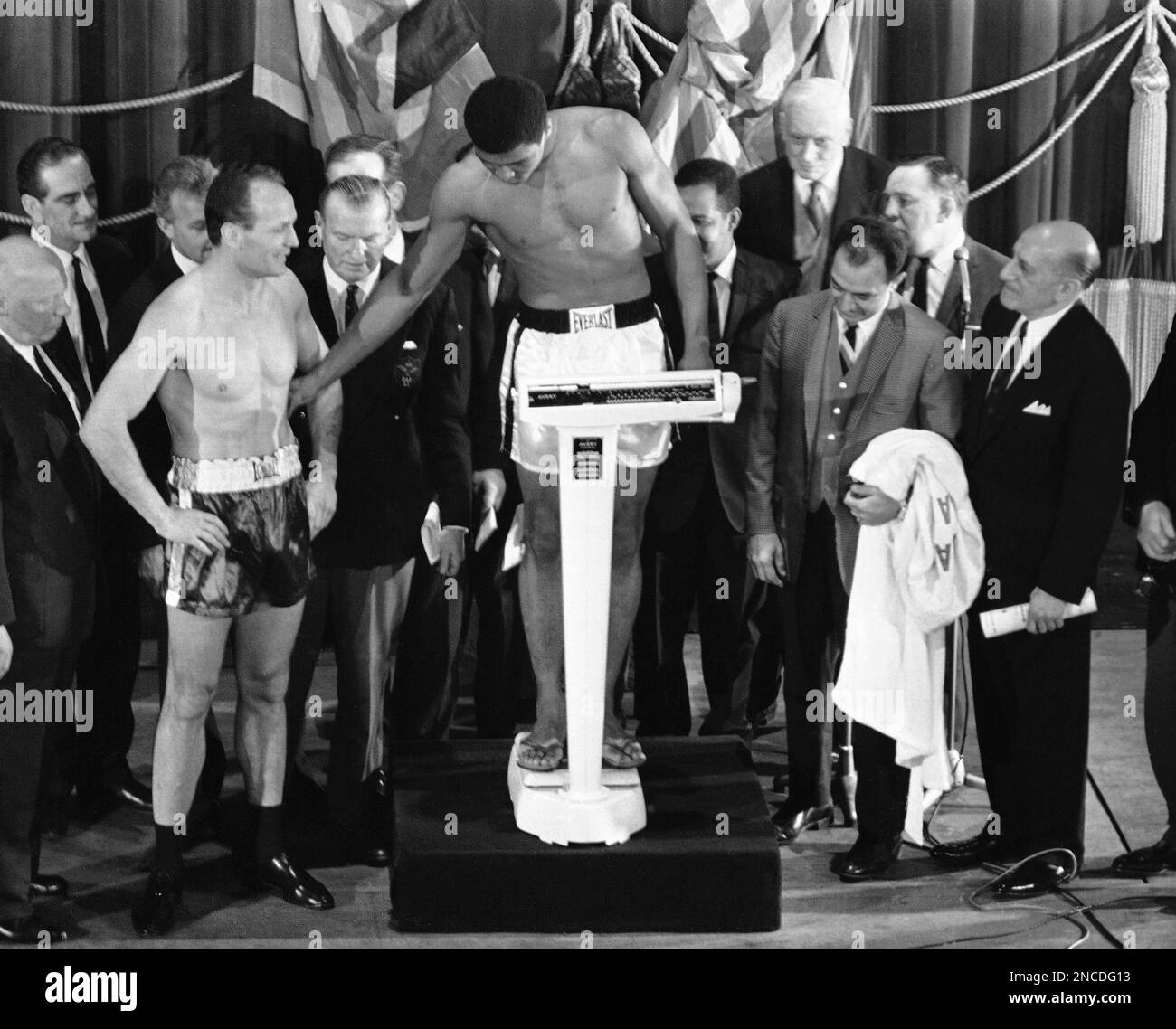 World Heavyweight champion Cassius Clay, Muhammad Ali, on scales, leans ...
