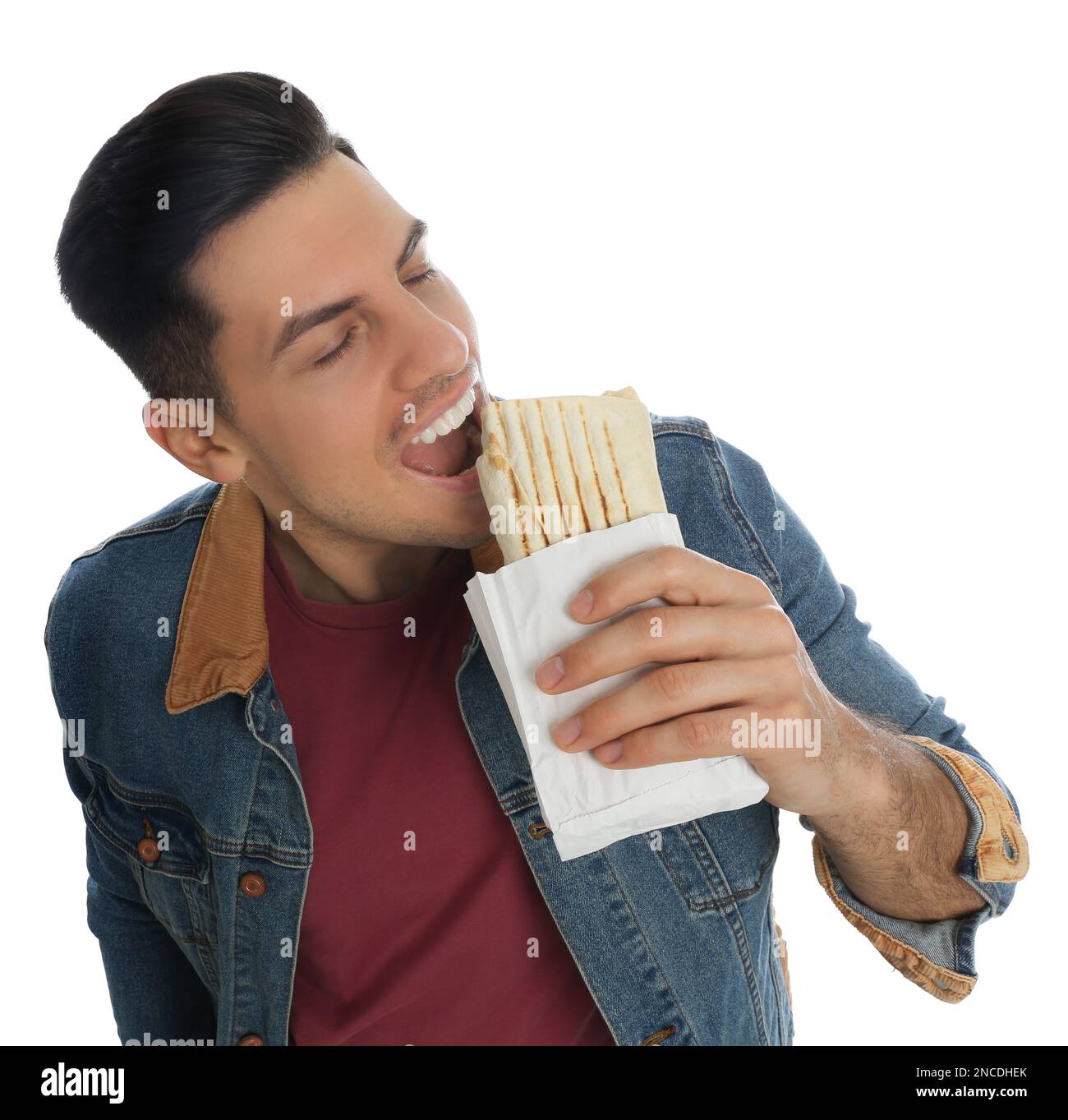 Man eating delicious shawarma on white background Stock Photo - Alamy