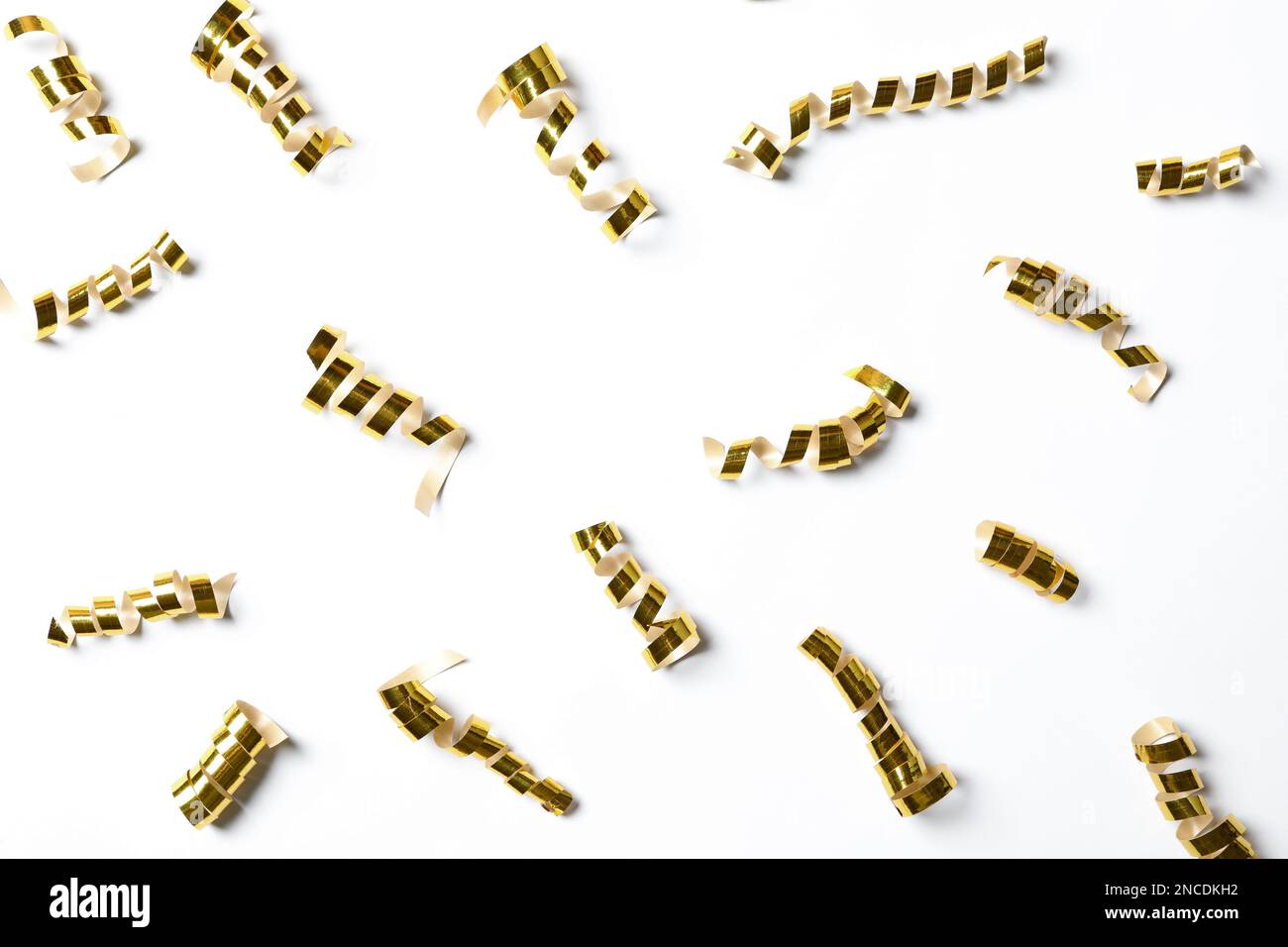 Shiny golden serpentine streamers on white background, top view Stock ...