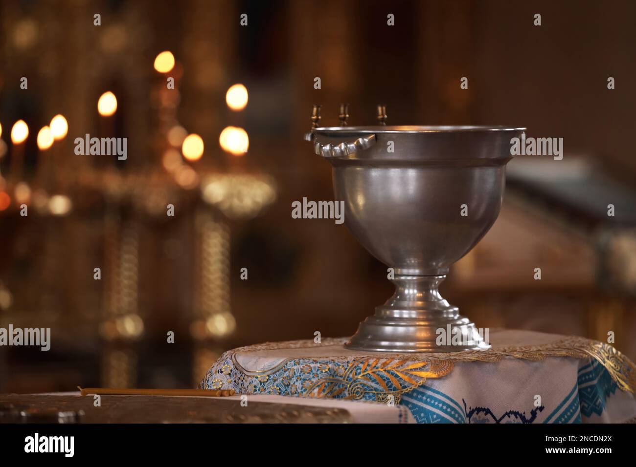 Silver vessel with holy water on stand in church, space for text ...