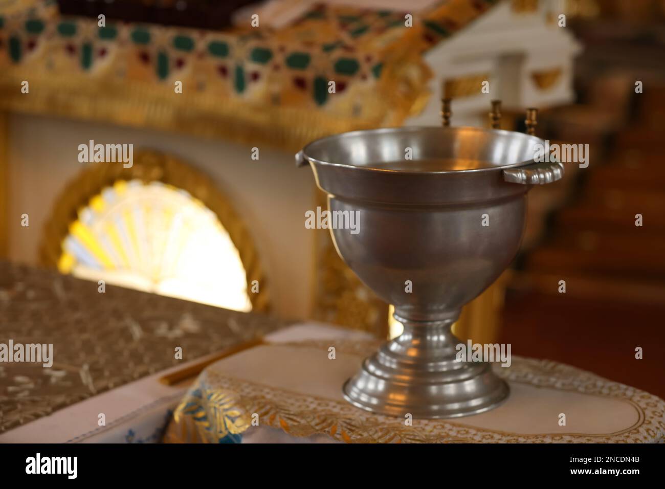 Silver vessel with holy water on stand in church, space for text ...