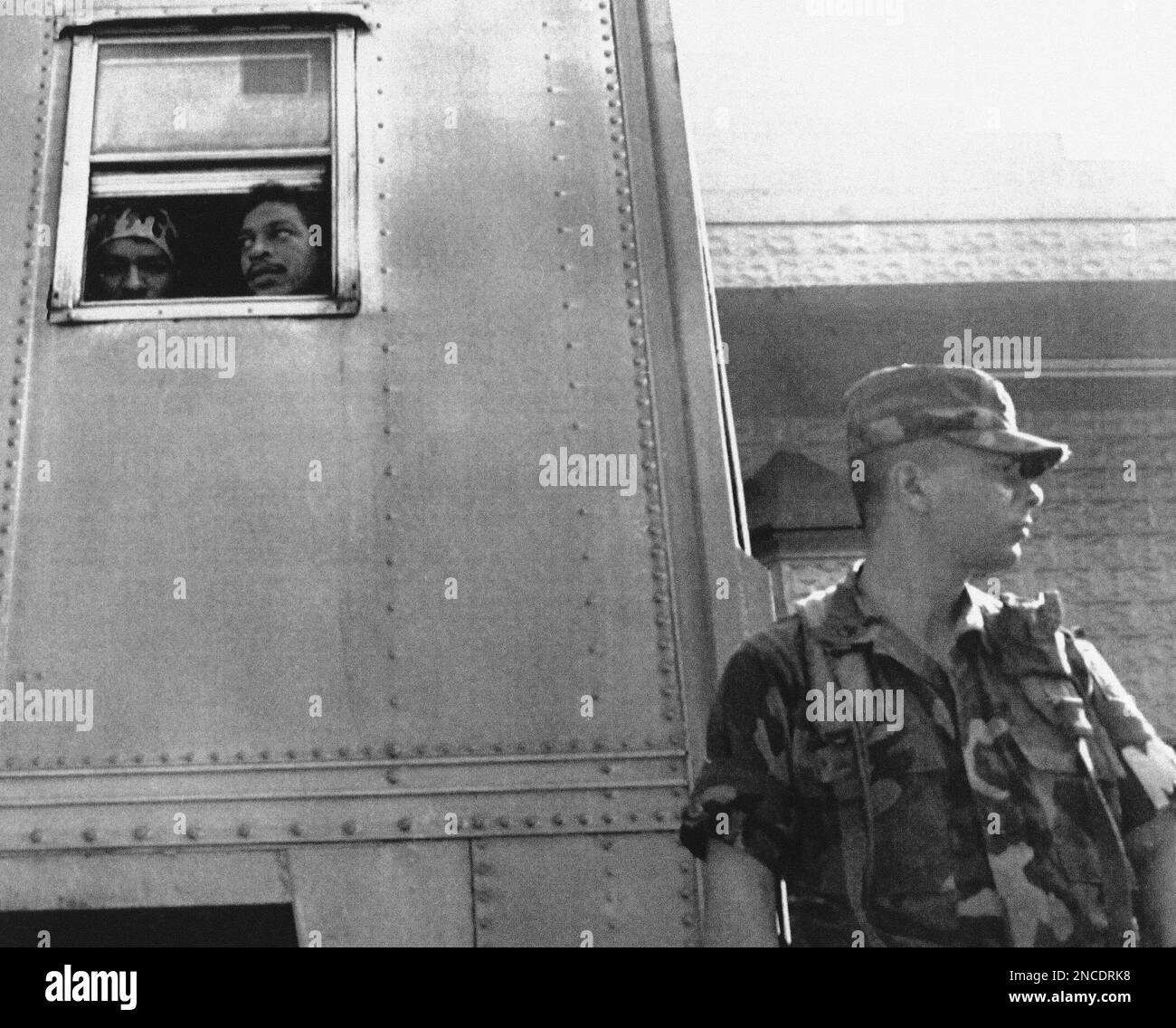 U.S. Military Police stand guard alongside a secured prisoner van ...