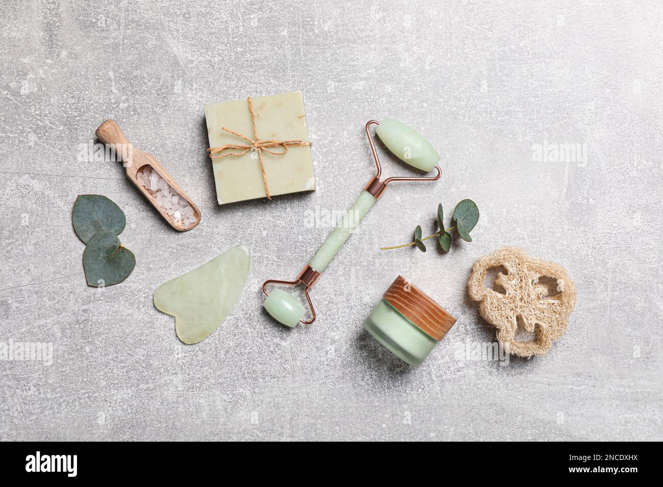 Flat lay composition with face roller and cosmetic products on light ...
