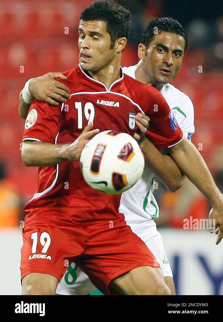 Iraq's Mahdi Kareem, rear, grabs Iran's Mohammad Gholami, during their AFC Asian Cup group D ...