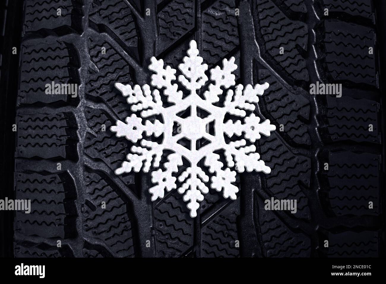 Winter tire with snowflake as background, closeup Stock Photo - Alamy