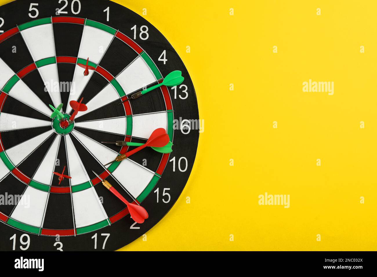 Dart board with arrows on yellow background, top view and space for ...