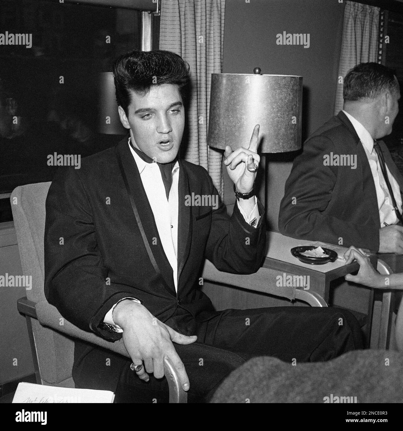 Singer Elvis Presley gestures during a press conference, showing his ...