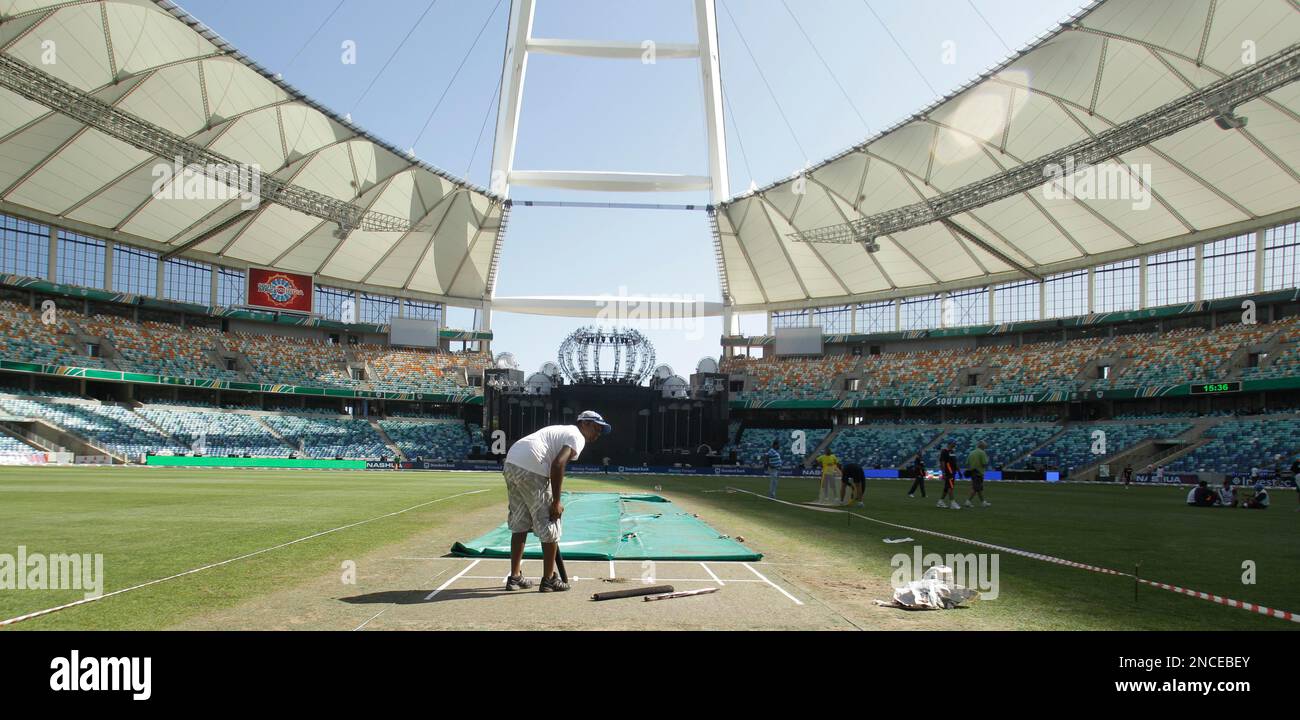 A television crew member works on the cricket stumps at the Moses ...
