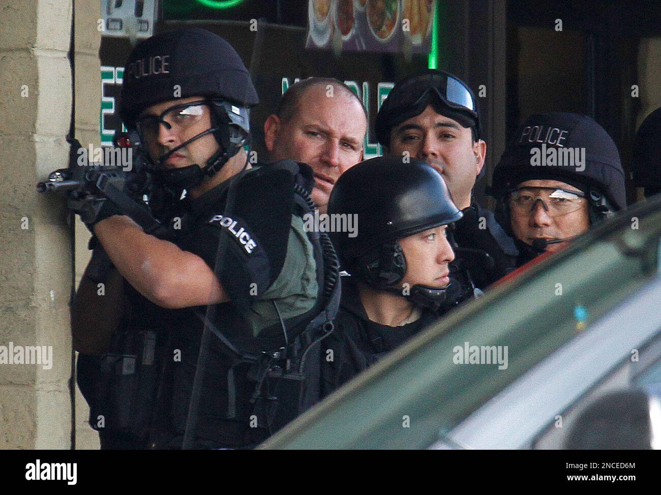 Members of a SWAT team cover the front entrance to a Bank of the West ...