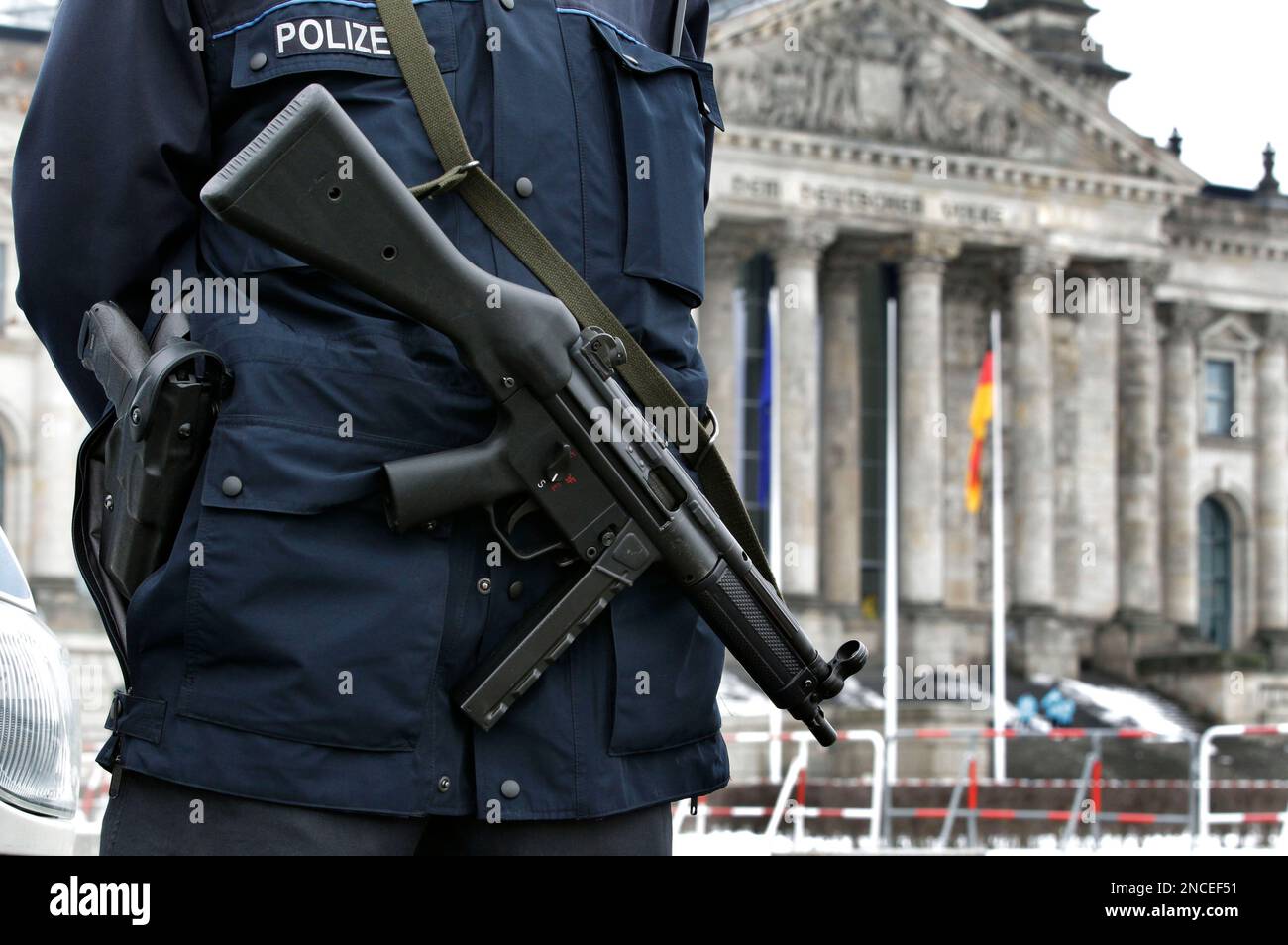 An armed police officer stands guard at the Reichstag building in ...