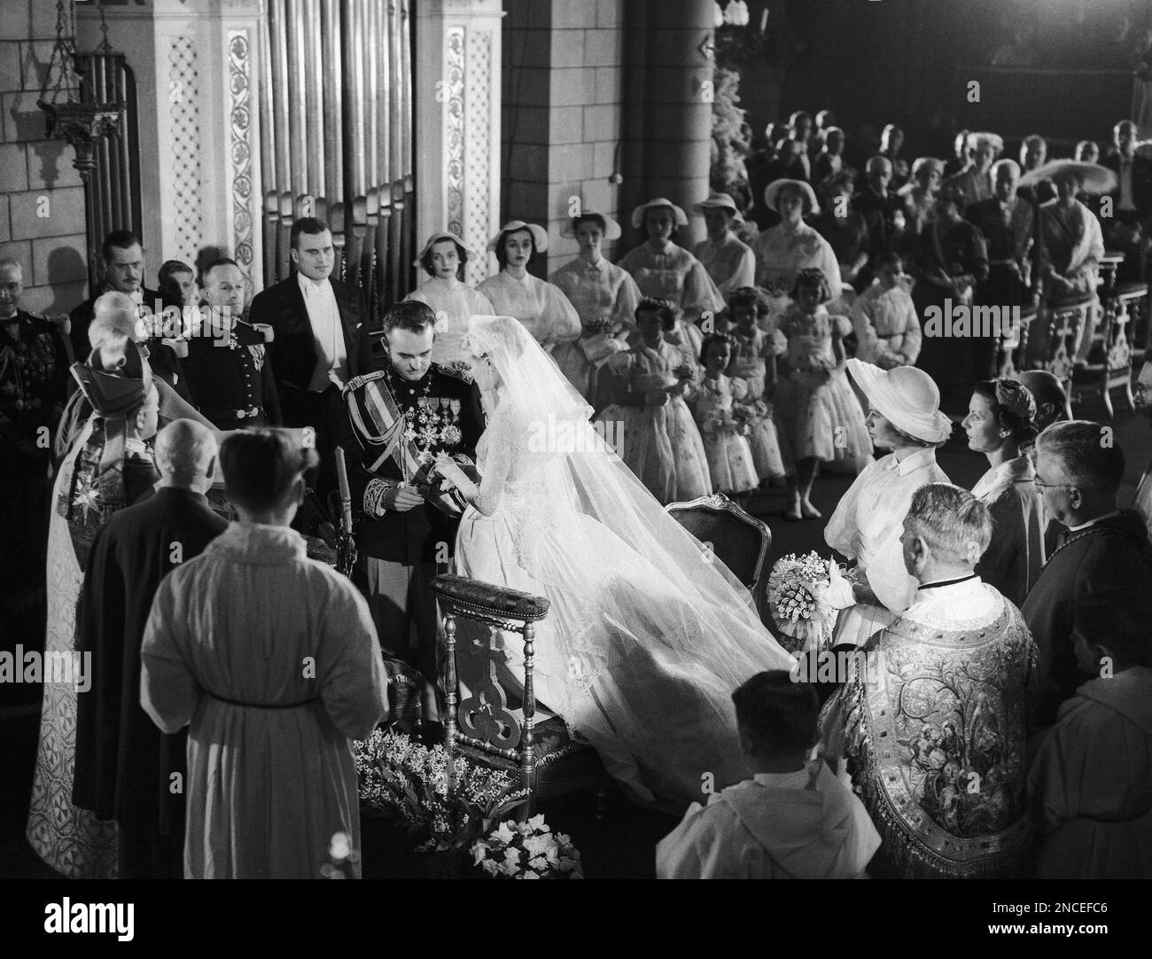 Princess Grace, formerly Grace Kelly, places the ring on the finger of ...