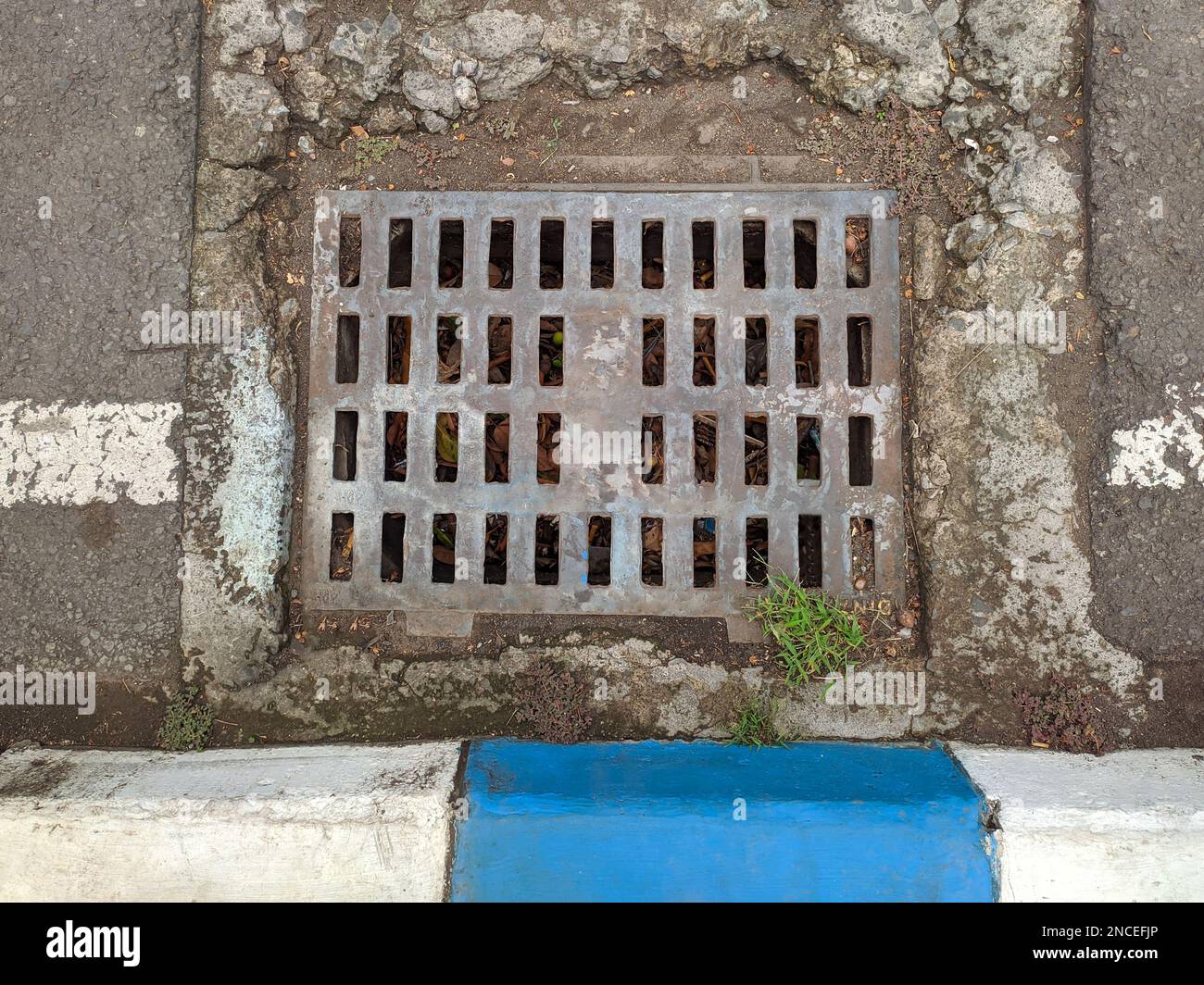 Water Drain on pavement road. Steel closed drains Stock Photo - Alamy