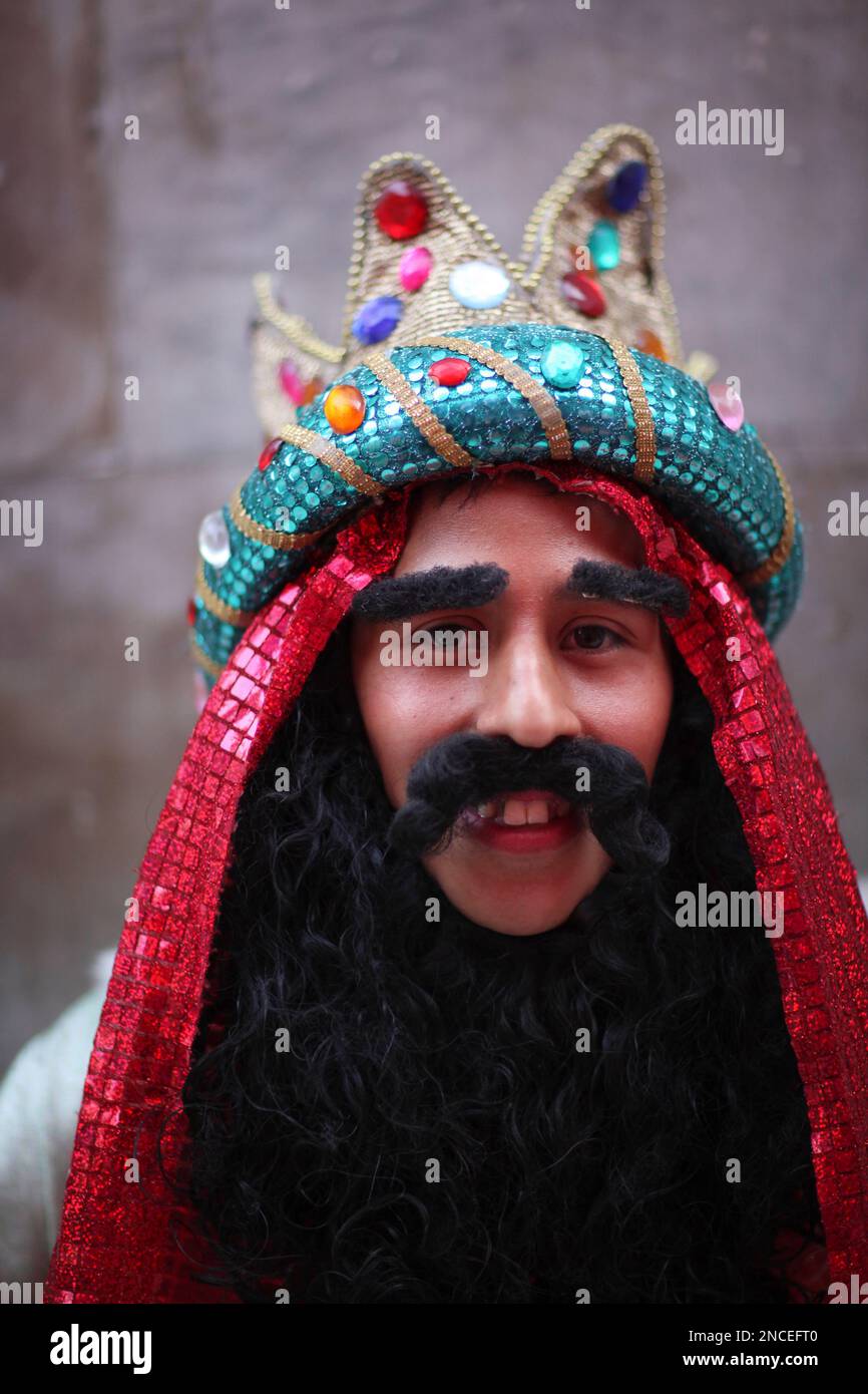 A man, dressed as one of the Three Kings, poses for a photo during the ...