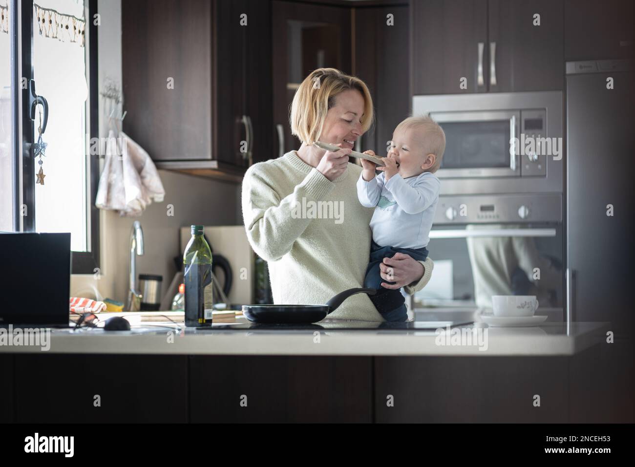 Happy mother and little infant baby boy cooking and tasting healthy ...