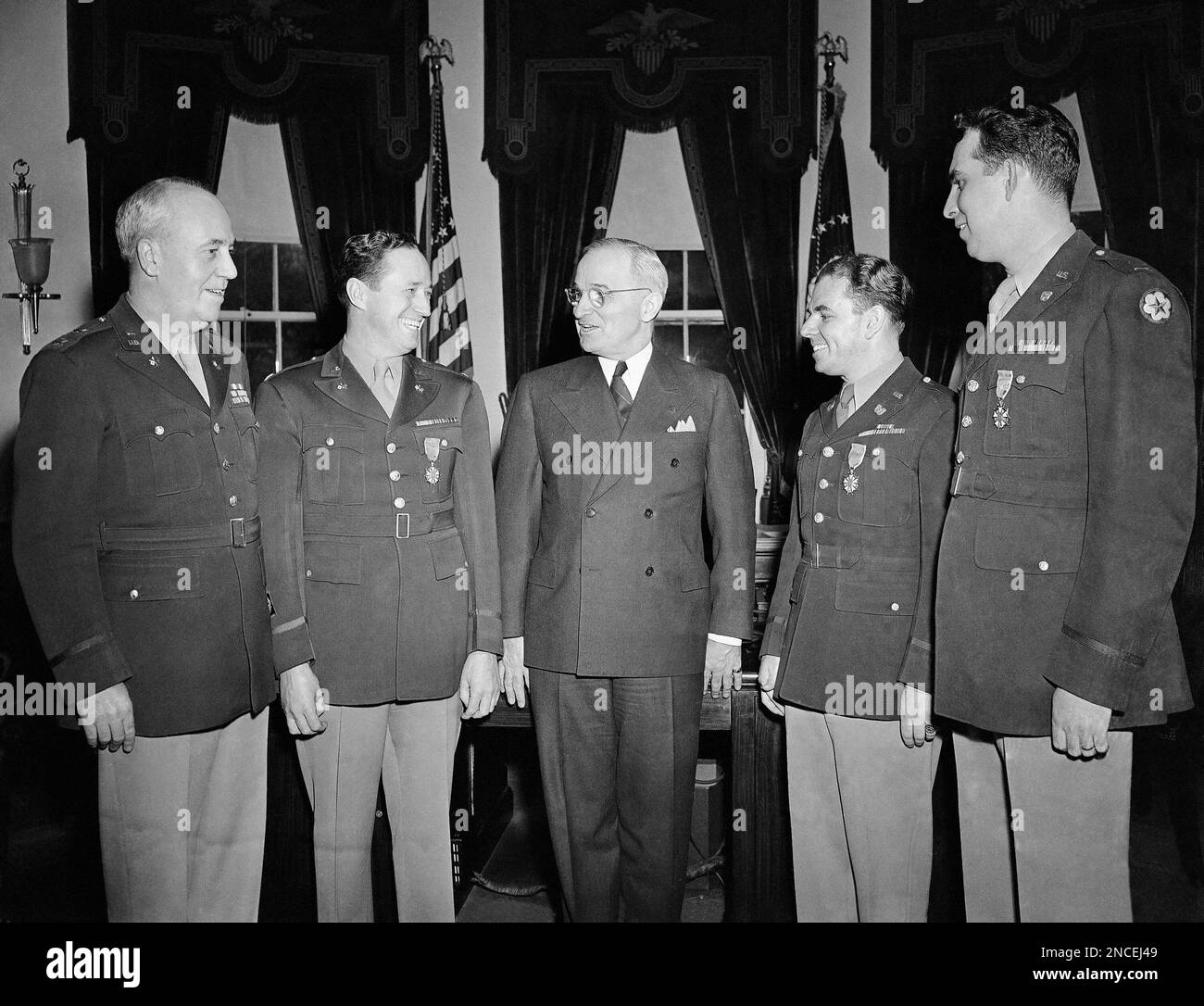 President Harry S .Truman, center, talks with three army men to whom he ...