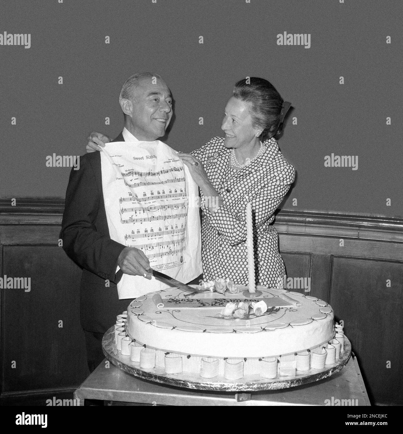 Mrs. Dorothy Rodgers, wife of composer Richard Rodgers, adjust bib ...