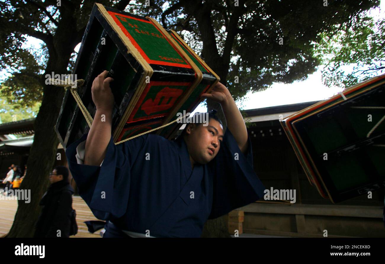 Sumo wrestlers carry boxes of items to prepare for the new year's sumo ...