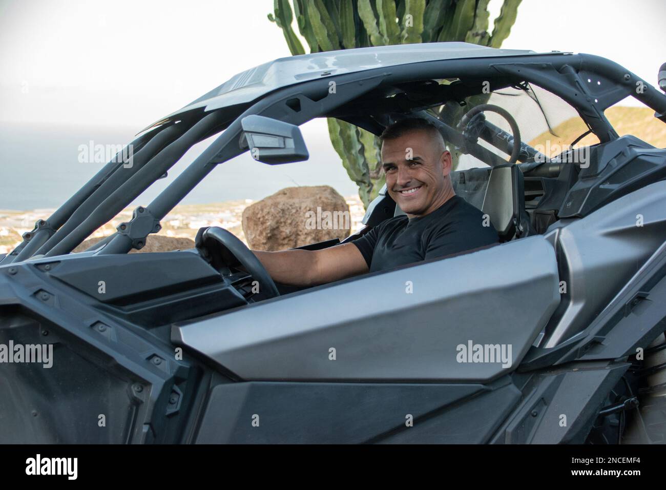 Caucasian buggy driver smiles at the camera from the cockpit of his ...