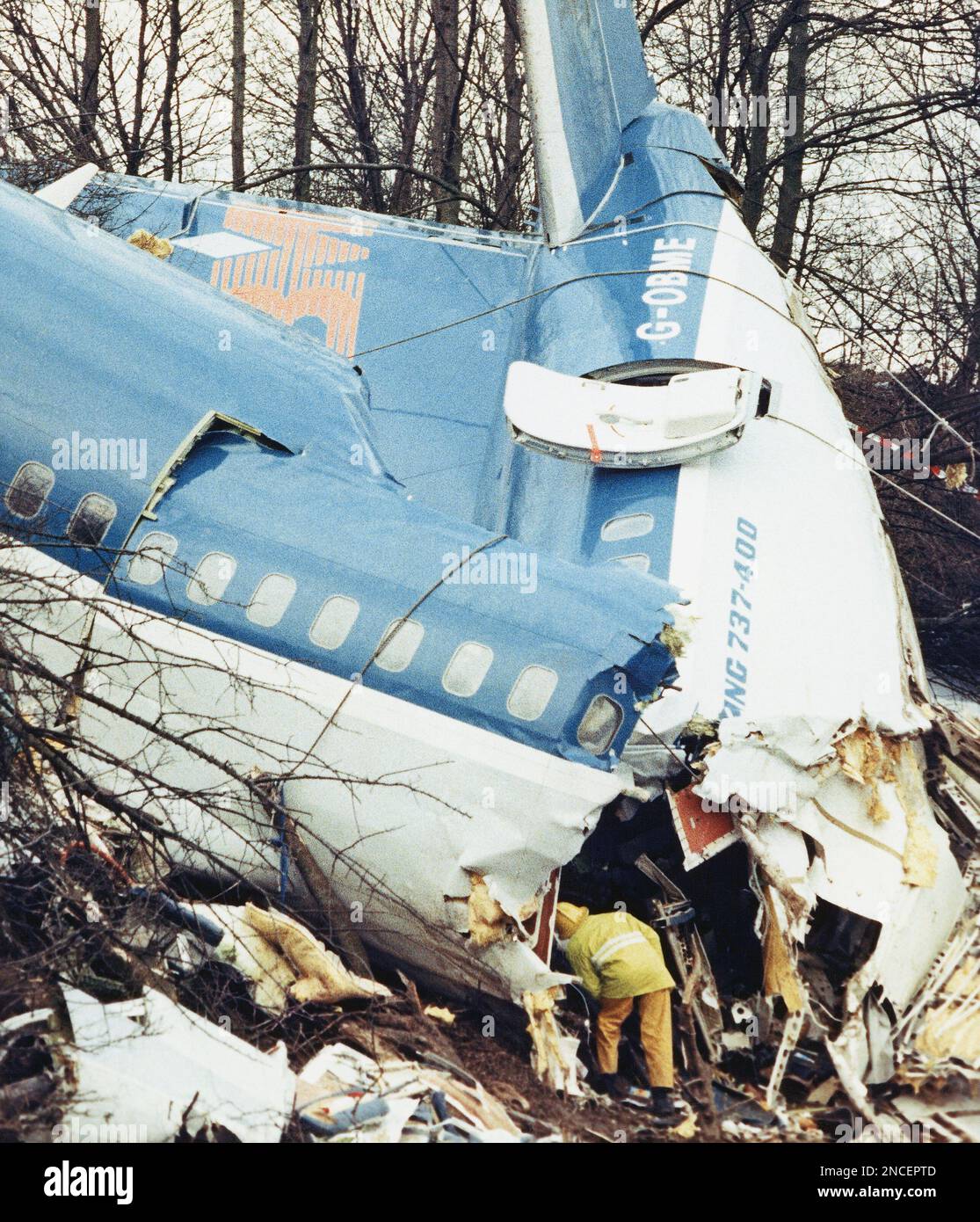 A fireman peers inside the shattered tail plane of the British Midland ...