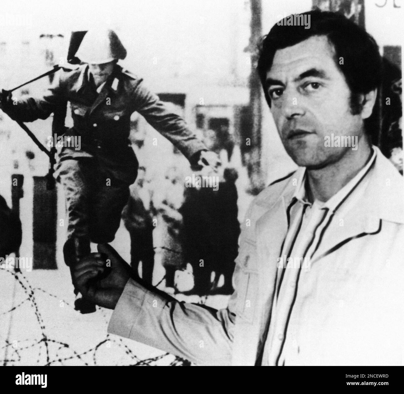 Conrad Schumann, 39, former member of the East German army points at ...