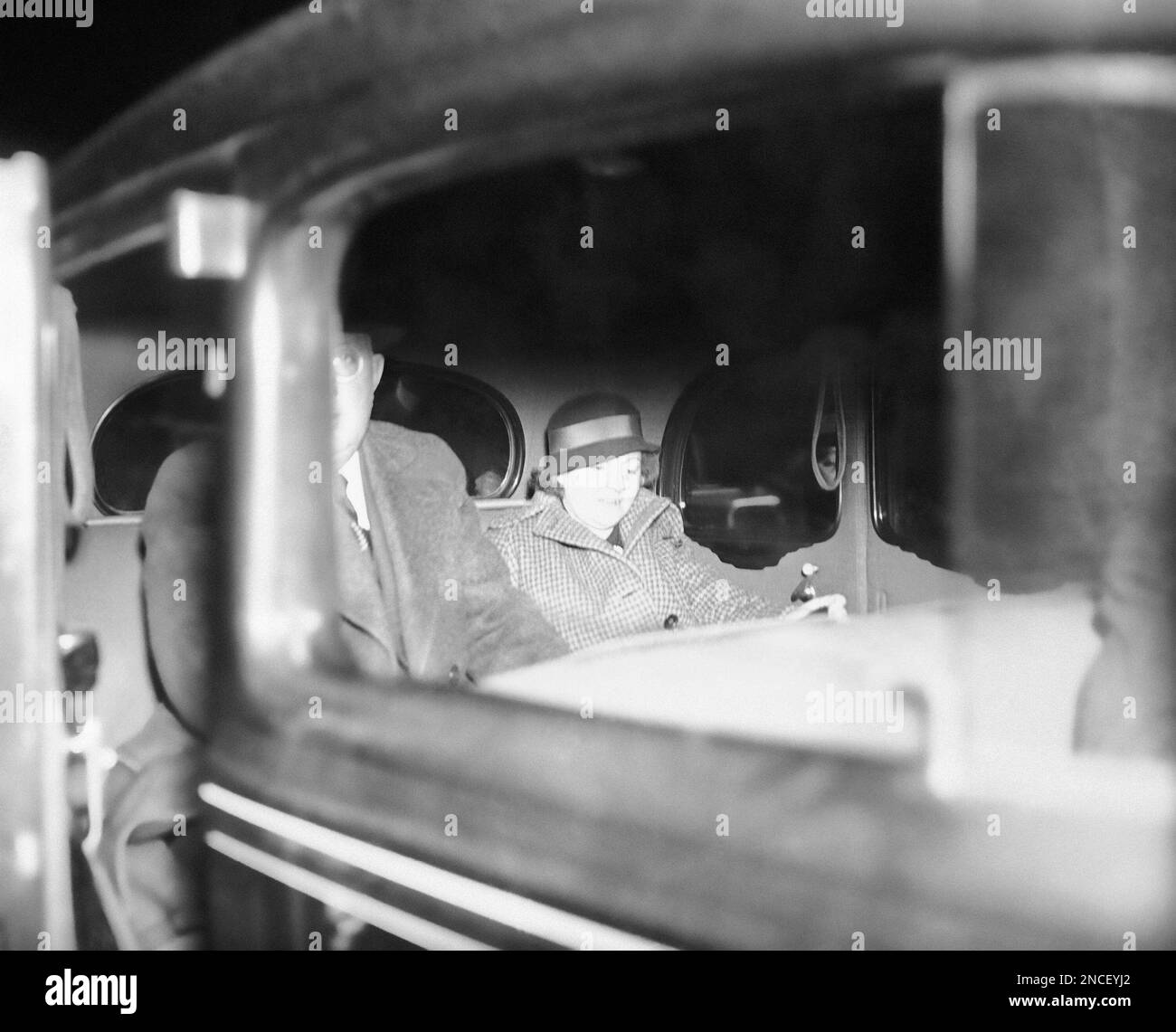 Marie McKeever sits in an auto beside a heavily armed federal agent as ...