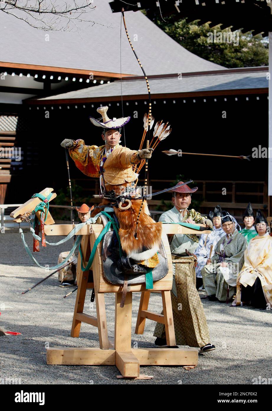 An archer dressed in a traditional Japanese warrior's attire shoots an ...