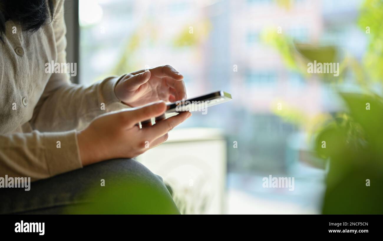 Side view, close-up image of a woman in comfy clothes using her ...