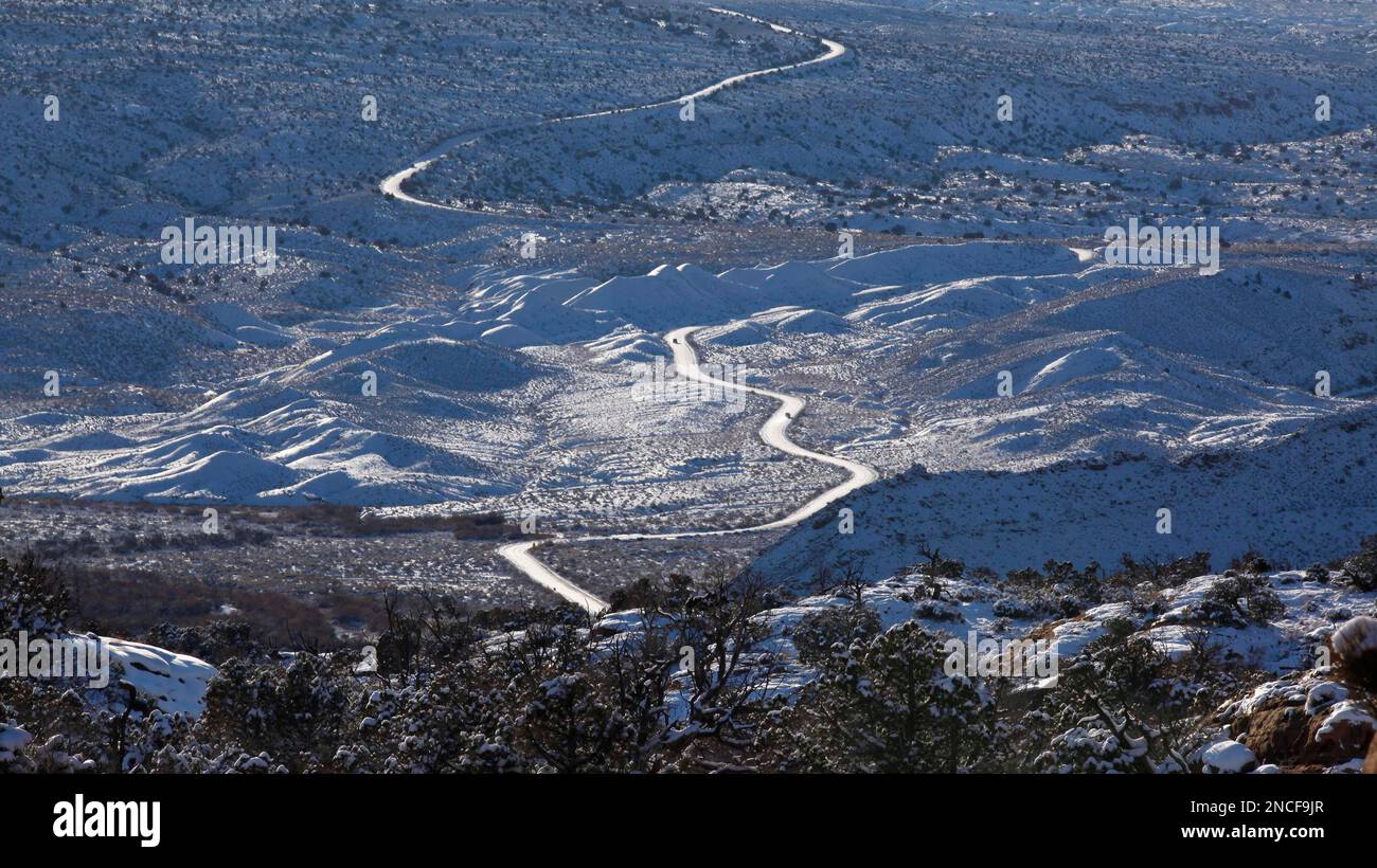 The park road, covered with ice and snow, descends into snow-covered ...
