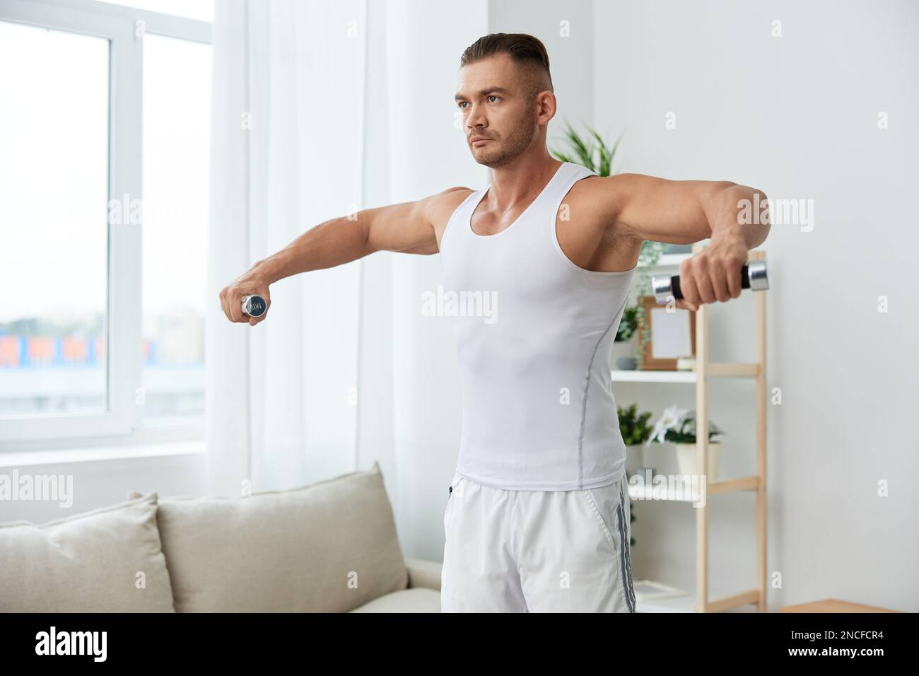 Man sportsman training at home with dumbbells, exercises for arms and ...