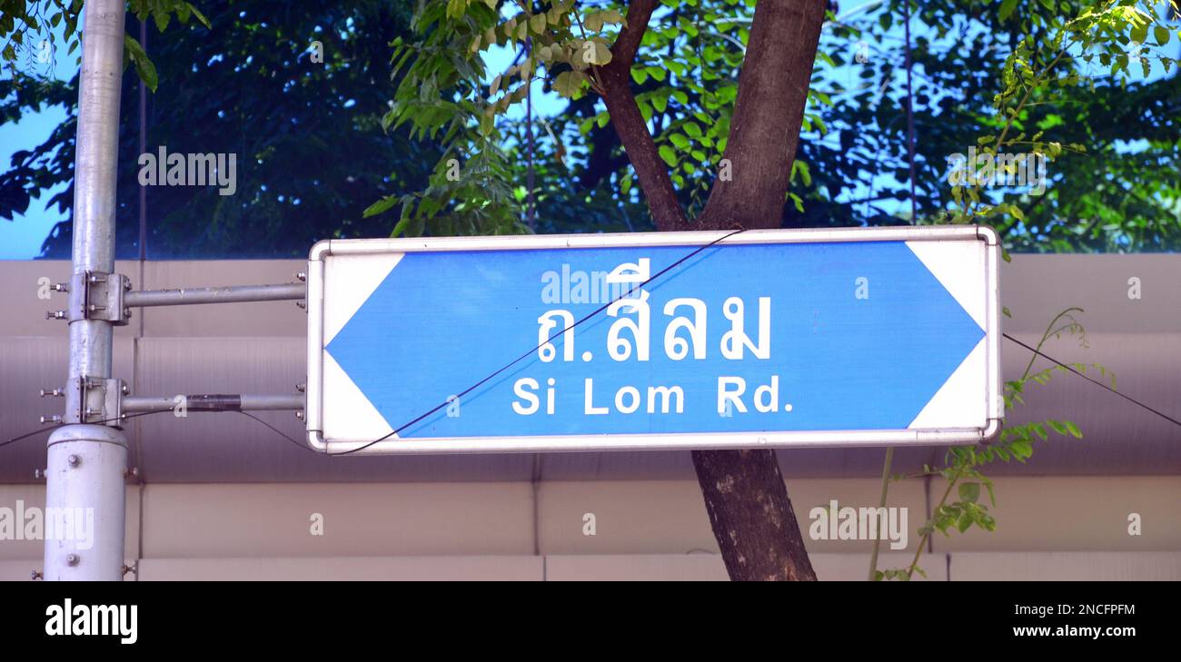 A road sign says Si Lom Road in English and in the Thai language in ...