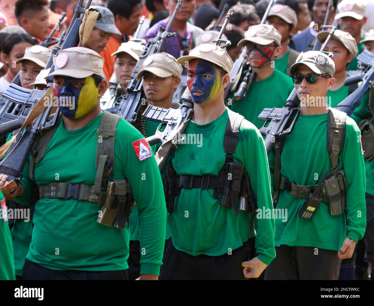 Some members of the communist New Peoples Army have their faces painted to hide their identity ...