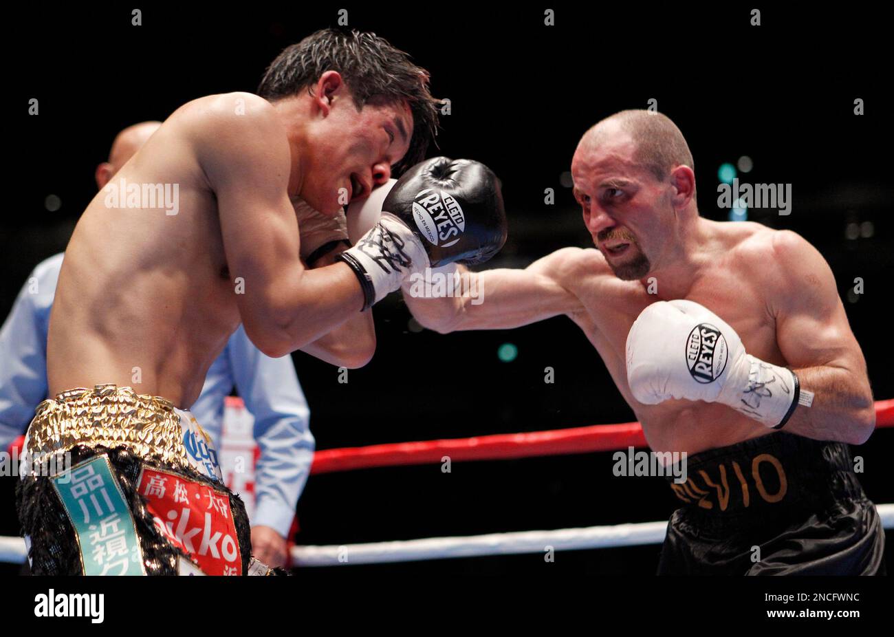 Romanian challenger Silvio Olteanu, right, delivers a right to Japanese champion Daiki Kameda ...