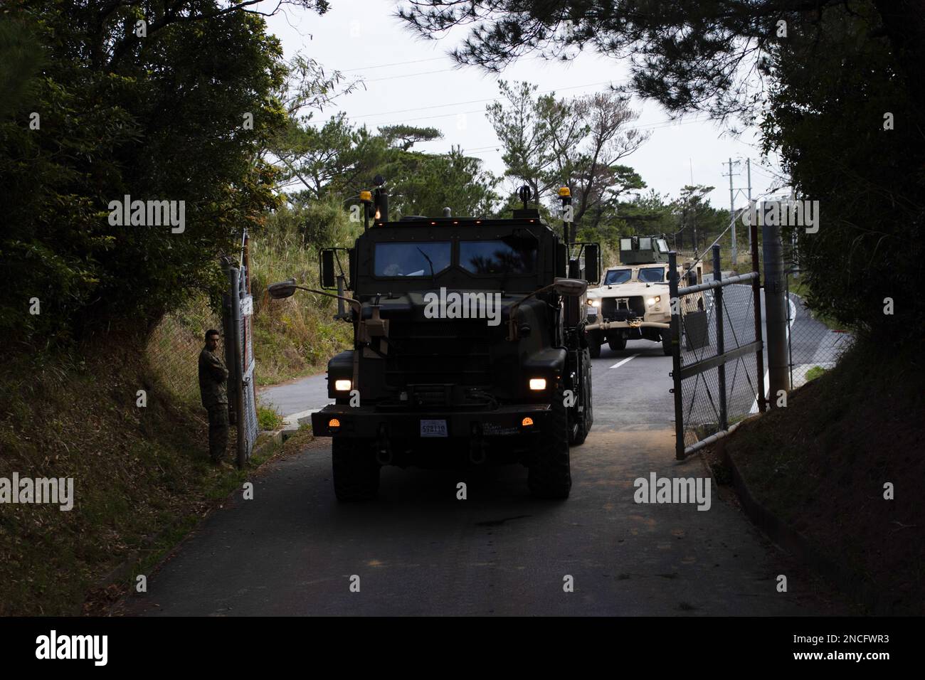 A U.S. Marine Corps convoy drives through a gate during a combat ...