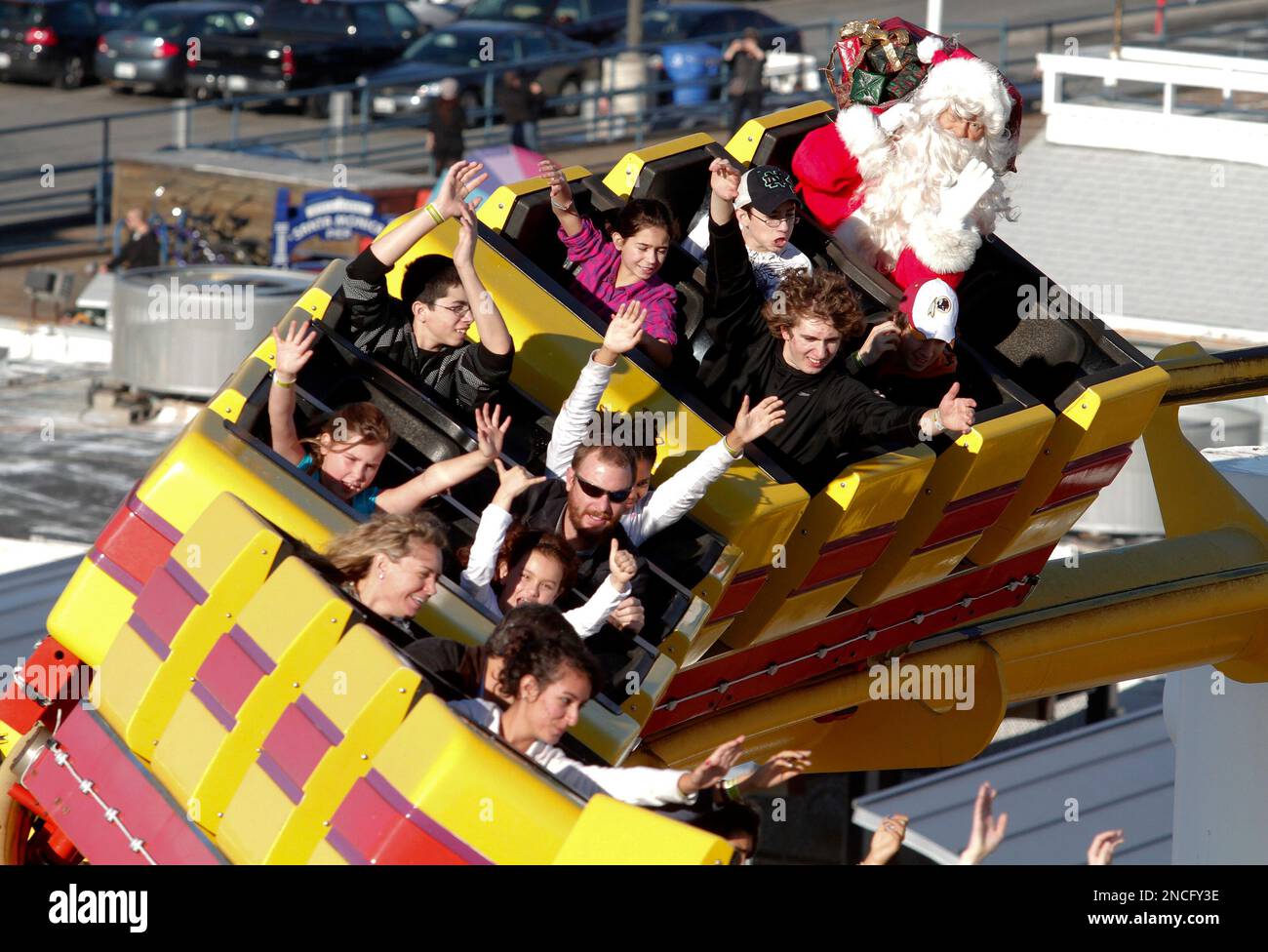 Visitors ride along with life-sized figure of Santa Claus on the roller ...