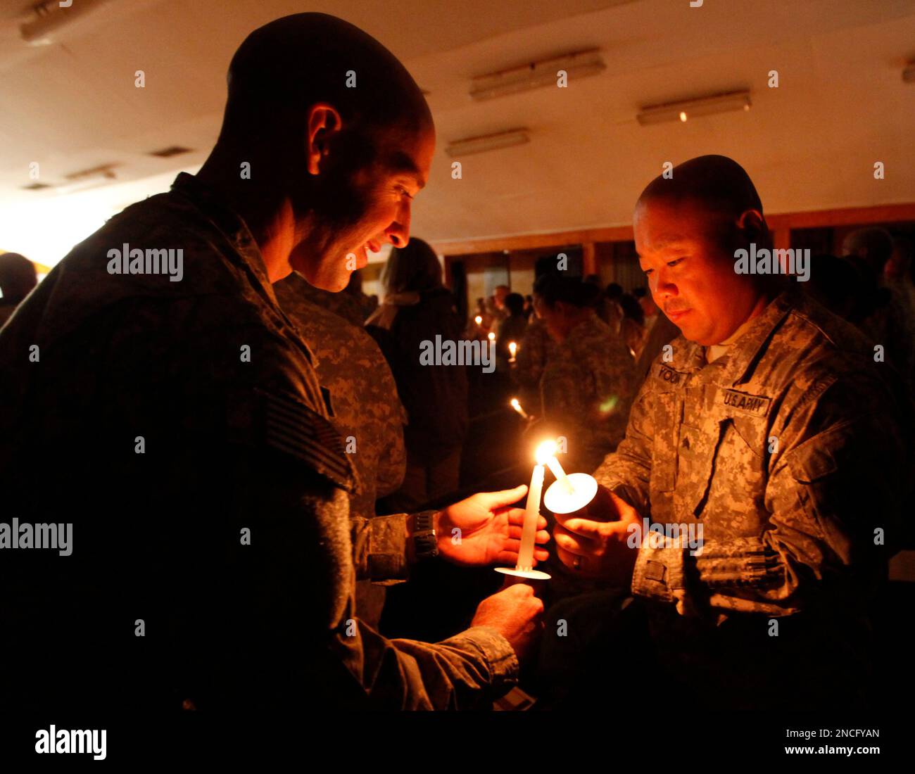U.S. troops are seen lighting candles during a Christmas Eve mass in a ...