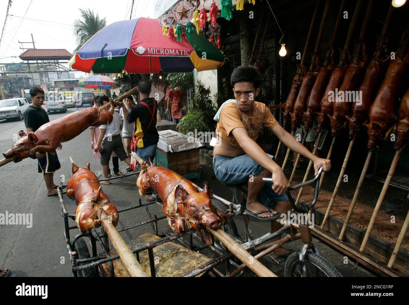 A man delivers roasted pig for display in Manila, Philippines, Thursday ...