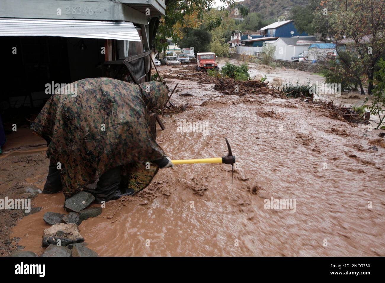 Jason Foulds shovels mud and debris in a flooded area of Silverado ...
